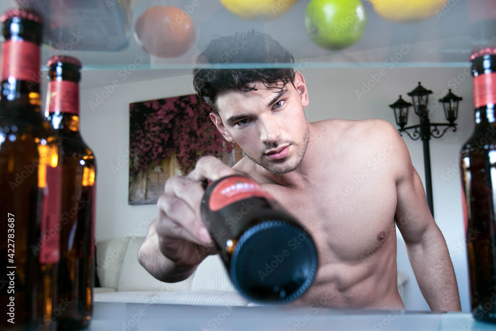 Handsome shirtless man with pecs and defined abs reaching into fridge ...