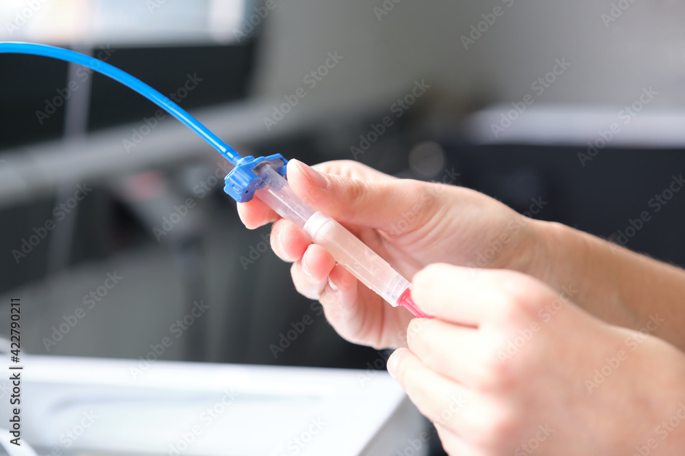 Researcher loading the ink cartridge of a 3D bioprinter to 3D print ...