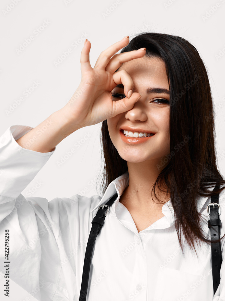 woman shows tongue and connected two fingers in front of her eyes Stock ...