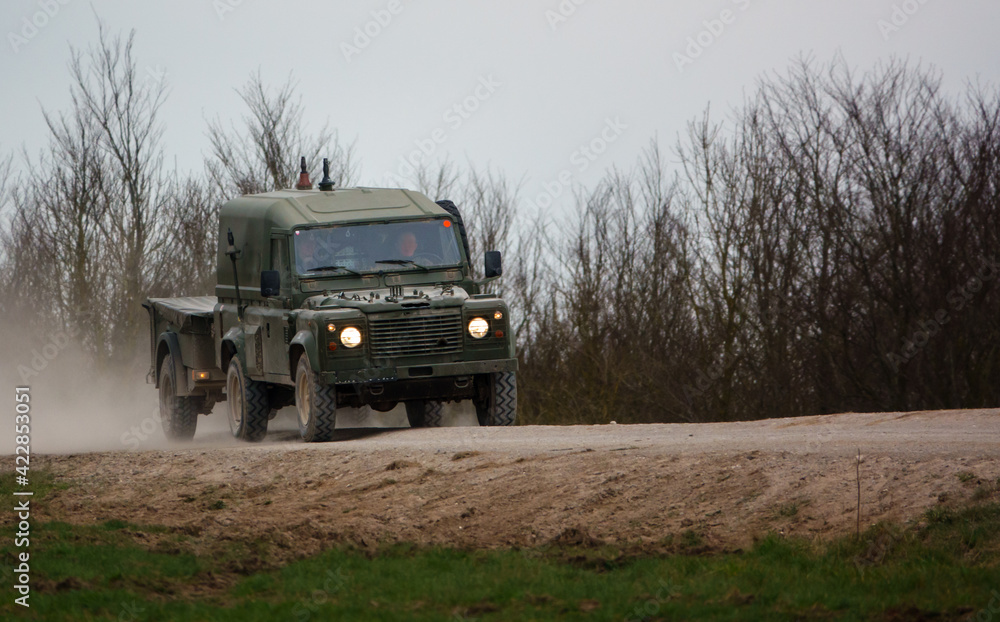 british army land rover defender 4x4 with attached trailer speeds along ...
