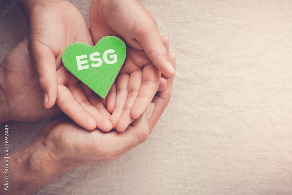 Adult and child hands holding green heart with ESG, Environmental ...