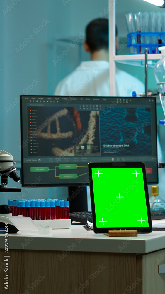 Microbiologist working on monitor in background analysing test samples ...