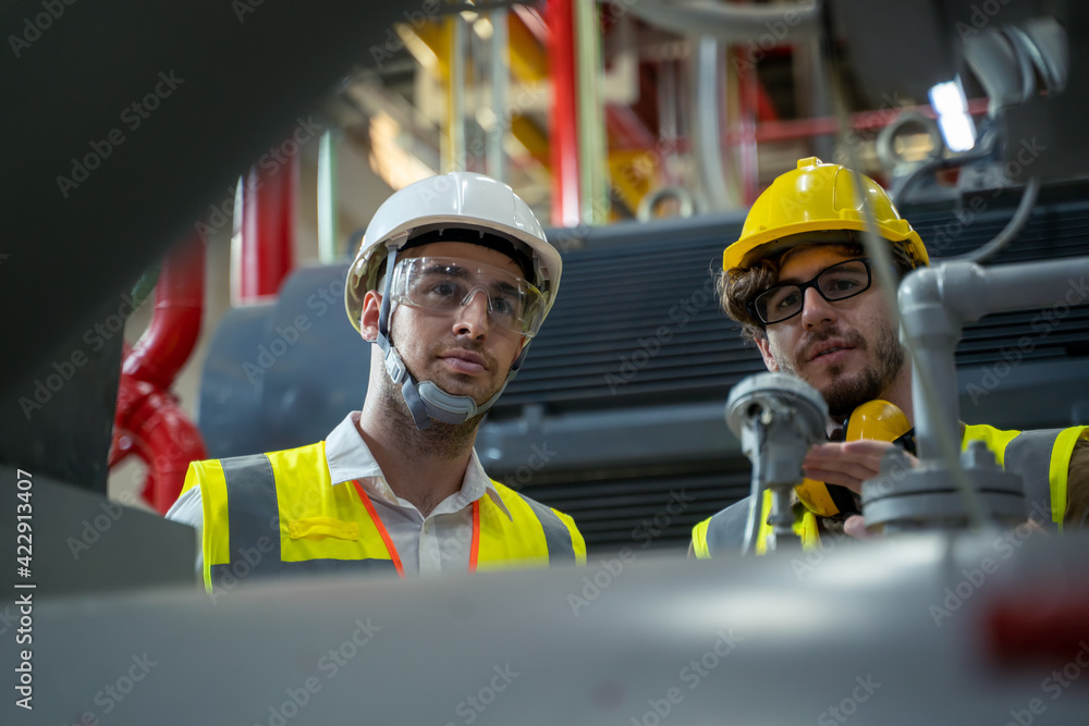 Two engineers working and checking information in a factory,They work a ...