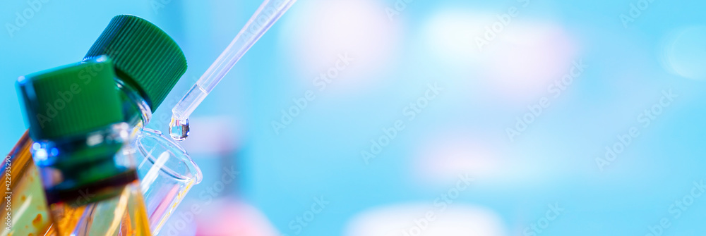 Chemical test tube and pipette with a drop of colorless liquid and two ...