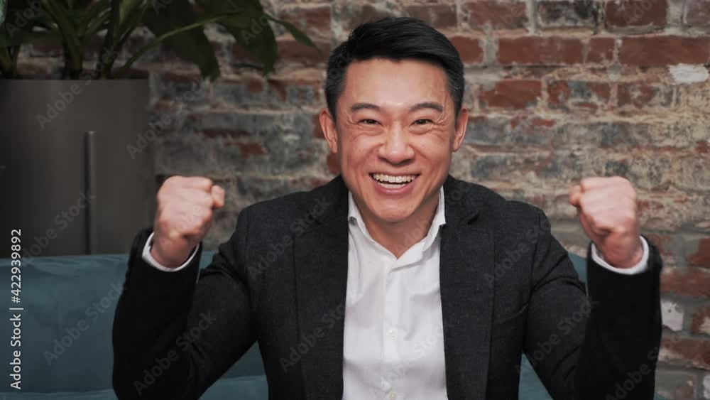 Excited young Asian business man feeling happy receiving new job ...