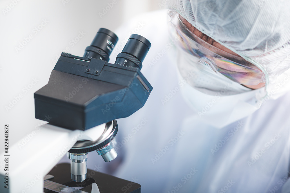 Scientist analyzing microscope slide at laboratory. Young woman ...