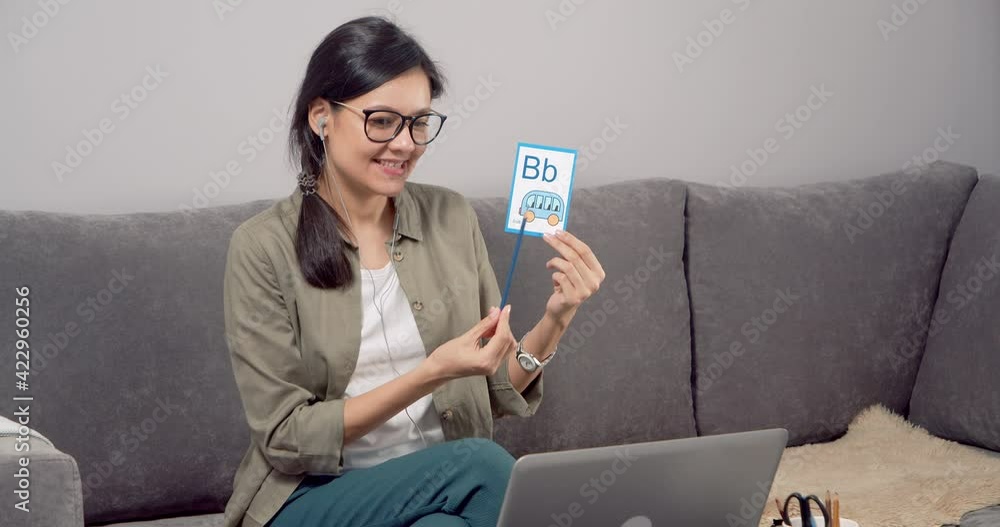 Young woman teacher showing picture with the alphabet, learning letters ...