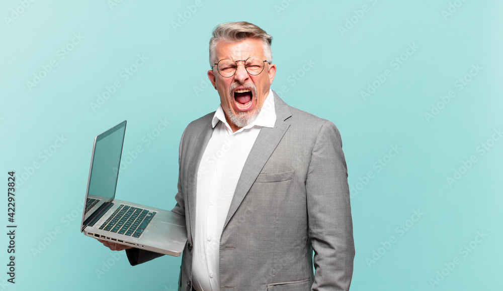 senior businessman shouting aggressively, looking very angry ...