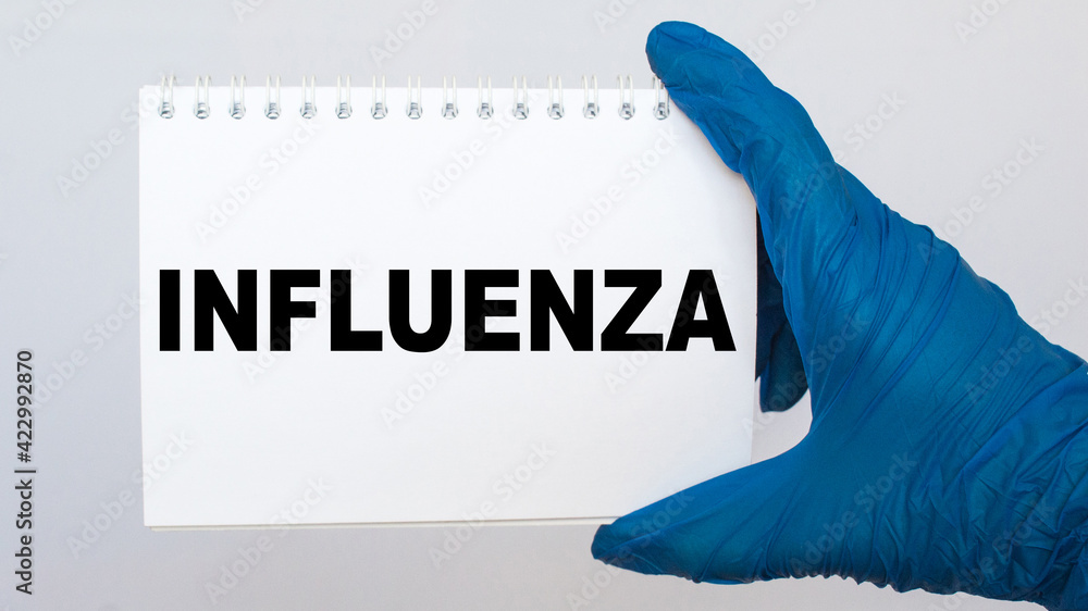 The doctor's blue - gloved hands show the word INFLUENZA - . a gloved ...