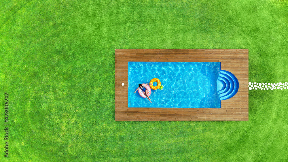 Aerial. Luxury swimming pool on the green grass lawn. Girl swims with ...