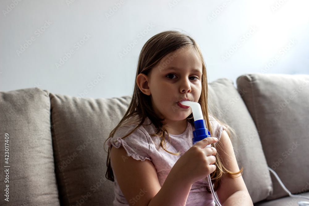 Beautiful girl uses a nebulizer at home, treatment of bronchitis and ...