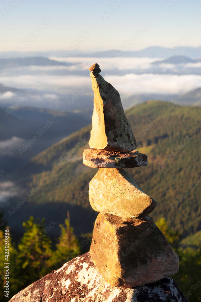 pyramid of stones at the top is a landart. Stock Photo | Adobe Stock