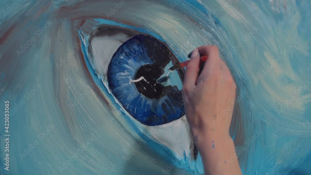 Close-up, as the artist draws in detail the human eye in his painting ...