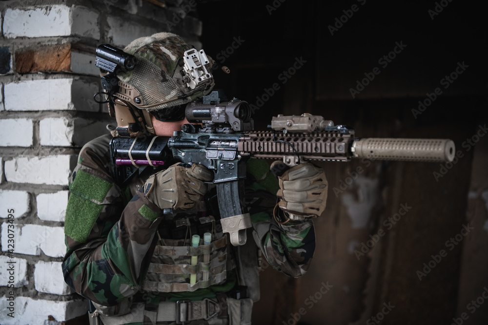 Military soldier in the form holds in the hands an assault rifle, check ...
