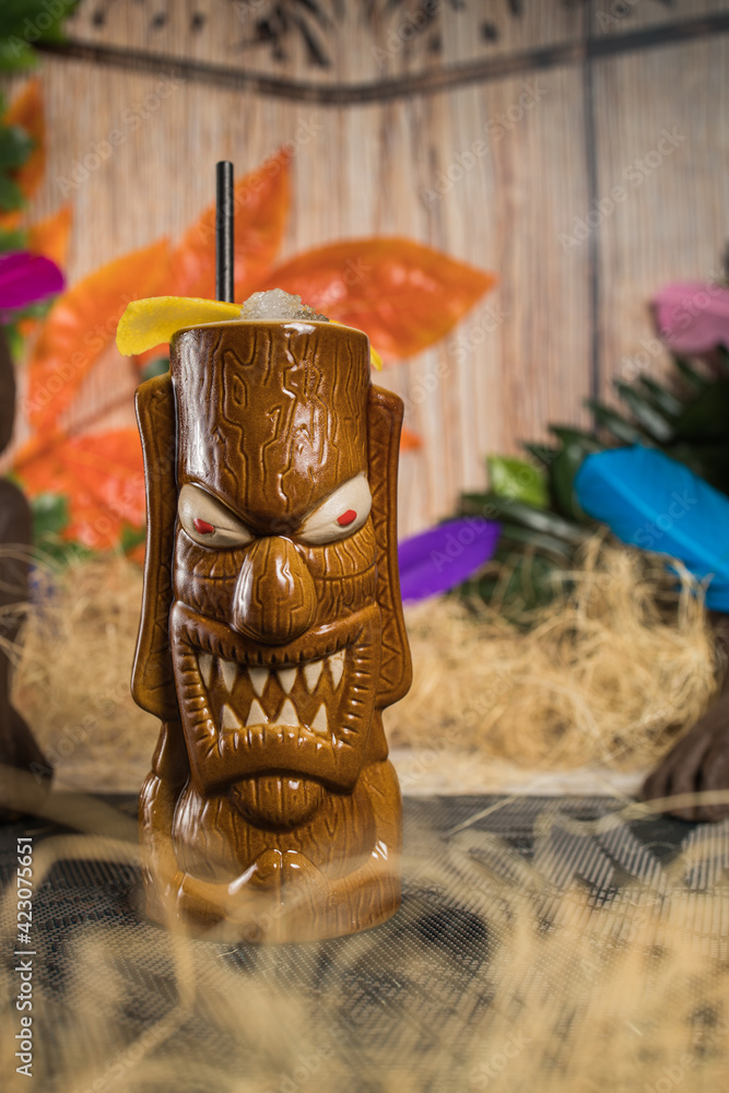 Brown sculptural tiki mug with alcohol drink decorated with straw and ...