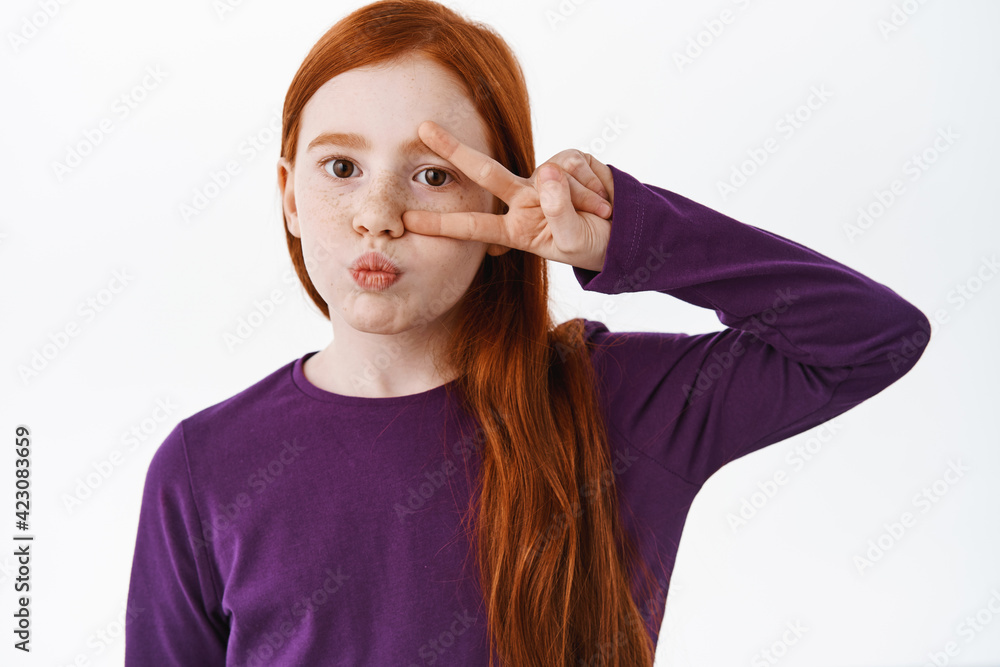 Adorable little girl with red hair and freckles shows kissing face and ...