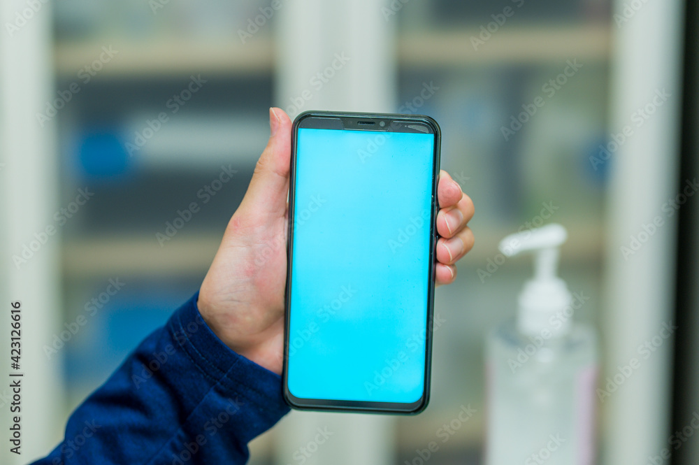 Hand held smartphone: man using phone with green and blue mock-up ...