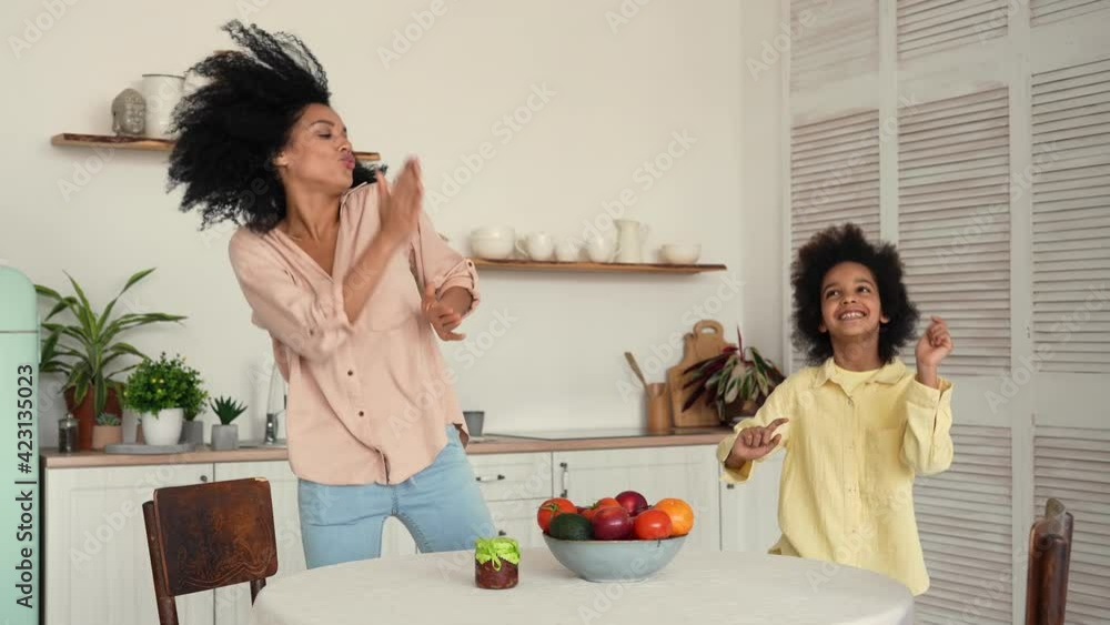 African American woman and girl dancing merrily, throwing a red apple ...