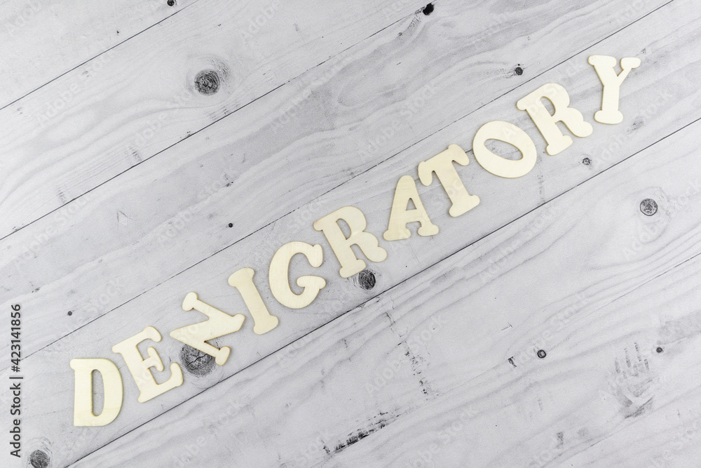 Denigratory - concept with alphabet letters on a diagonal light grey ...