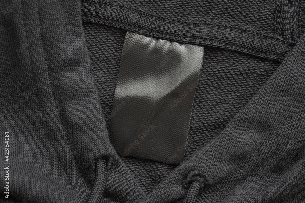 Blank black laundry care clothes label on black fabric texture ...