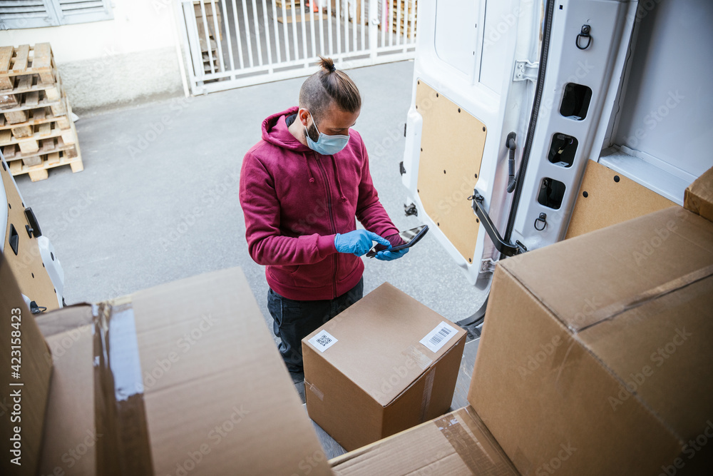 Young man shipper with van during the delivery round in the global ...
