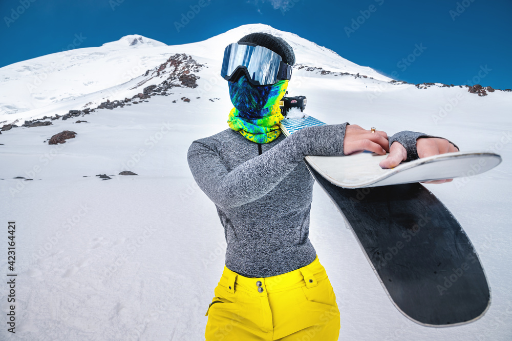 A young slender woman in a ski mask hat and a comforter on her face ...