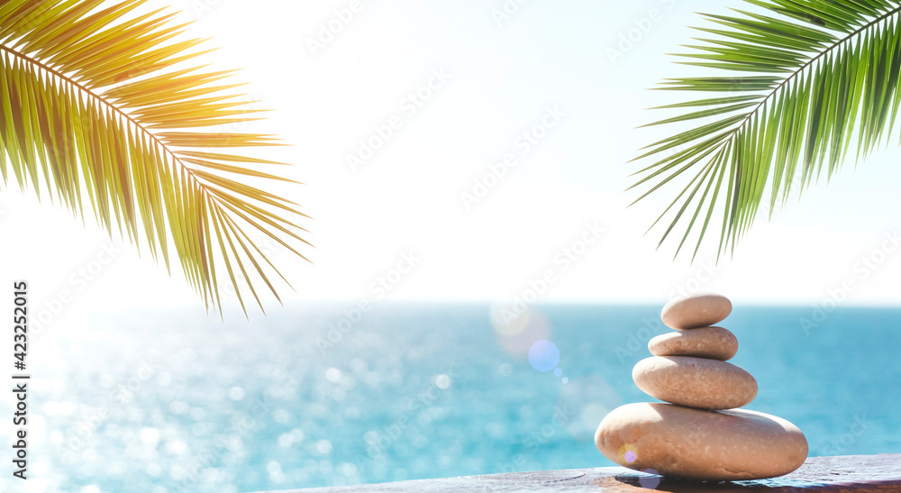 Zen relax background. A pyramid of stones on the beach in clear sunny ...