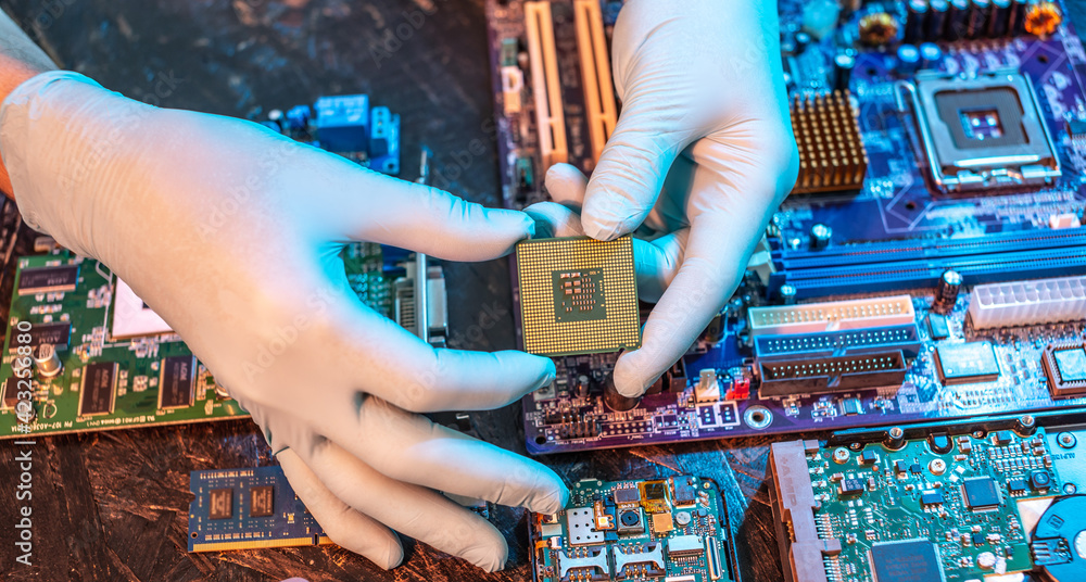 Engineer's gloved hand is holding the CPU chip on the background of the ...