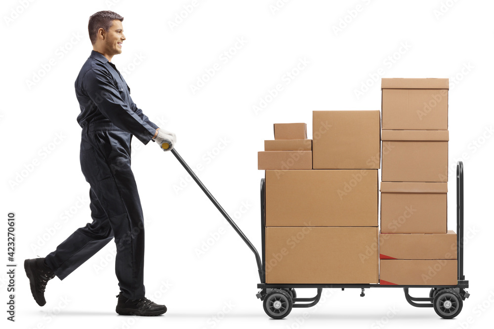 Male worker in a uniform pushing a hand truck loaded with boxes Stock ...