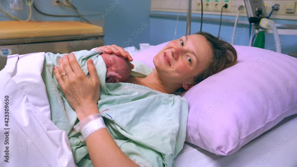 Mother and newborn. Child birth in maternity hospital. Young mom ...