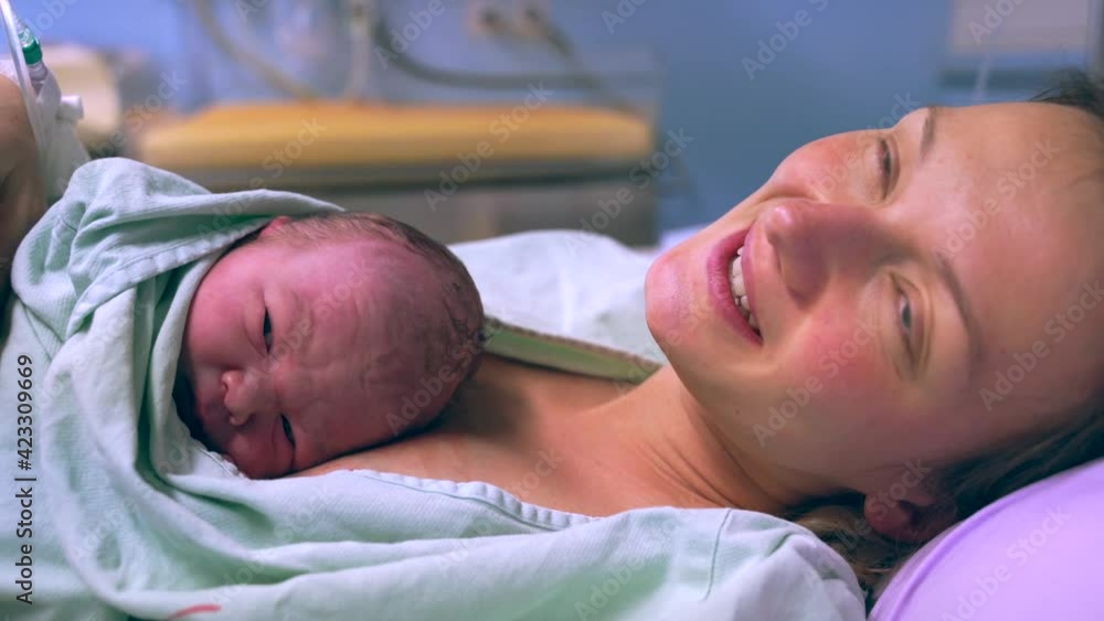 Mother and newborn. Child birth in maternity hospital. Young mom ...