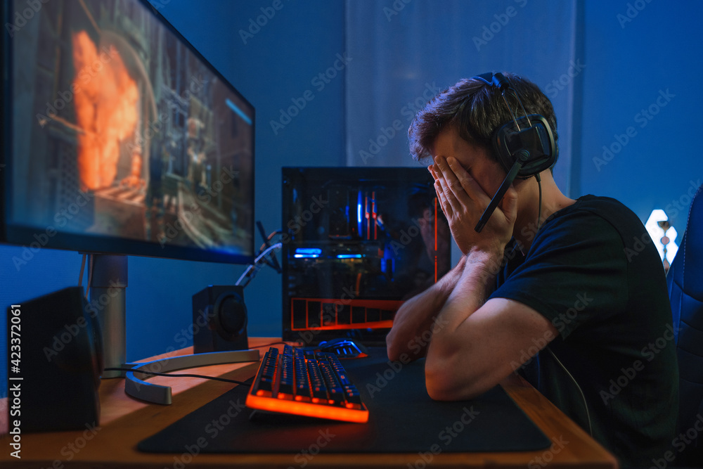 Young caucasian esport gamer wearing headphones feel painful and upset ...
