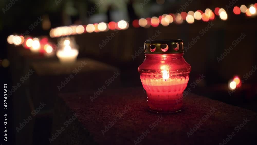 Candles burning at a cemetery during all saints day. Shallow depth of ...