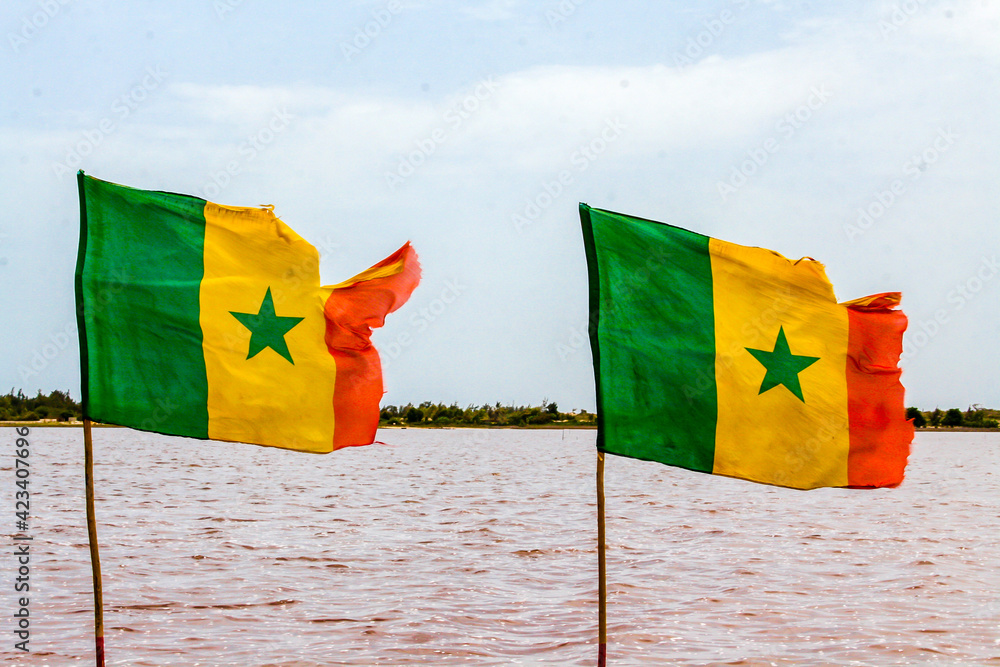 Senegal, Senegalese flags torn on a dugout canoe along Lac Rose. Stock ...