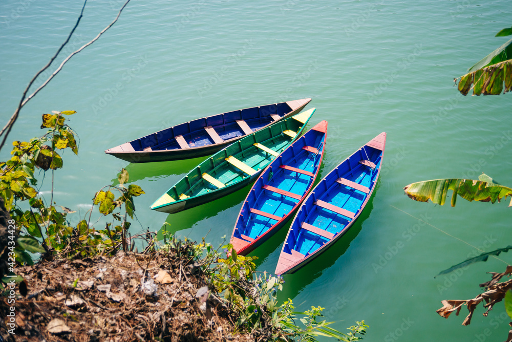 Phewa Lake with multicoloured boats in the valley of Pokhara in central ...