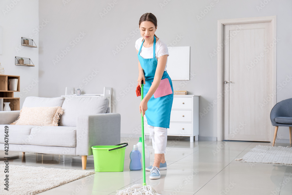 Young woman mopping floor in room Stock Photo | Adobe Stock