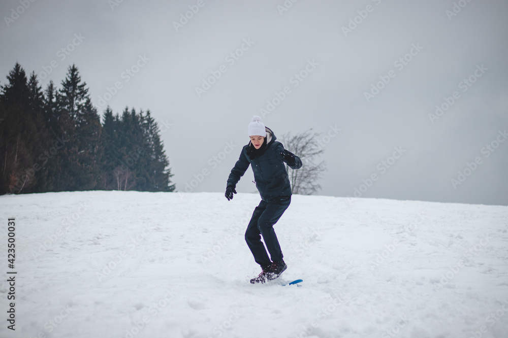 Youth falls from a plastic snowboard and falls hard on the snow and ...