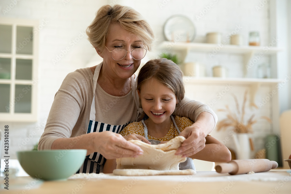 Loving mature Caucasian 60s grandmother roll dough bake bread or sweet ...