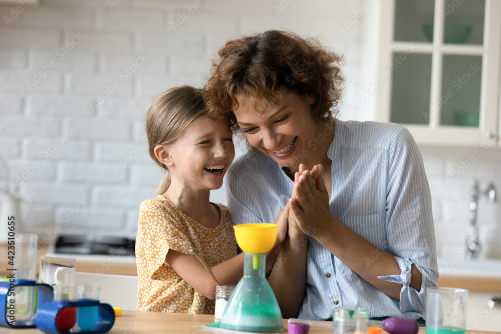 Smiling little girl child have fun playing chemistry lab childish game ...