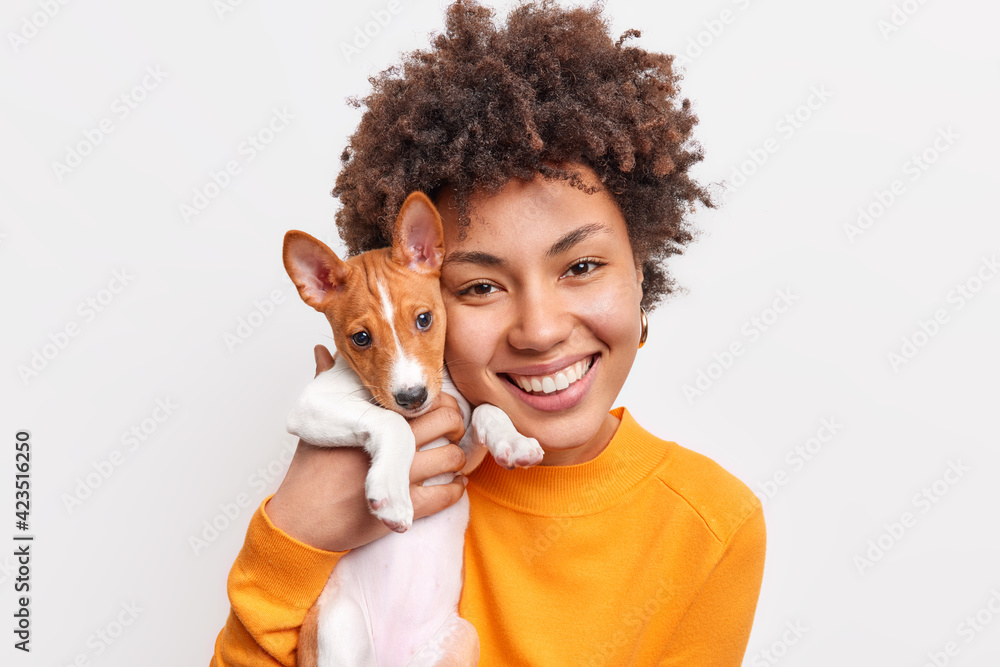 Portrait of lovely young Afro American woman smiles gently holds small ...