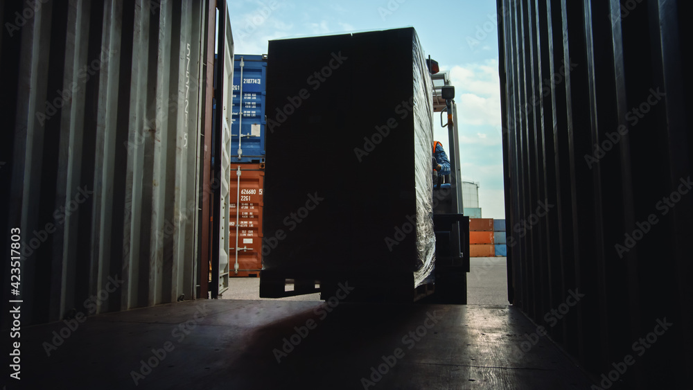 Forklift Driver Loading or Unloading a Shipping Cargo Container with a ...