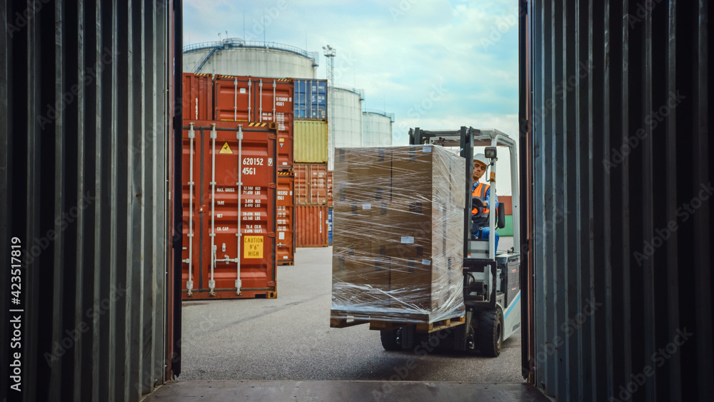 Foto de Forklift Driver Loading or Unloading a Shipping Cargo Container ...