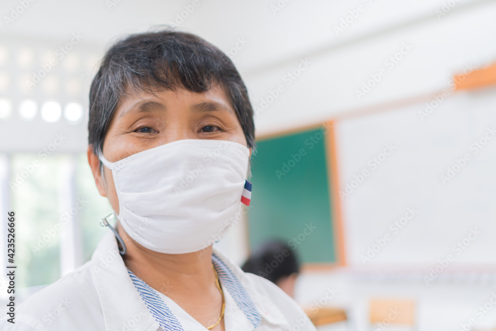 Asian Female teacher wearing white face mask safety during COVID-19 ...