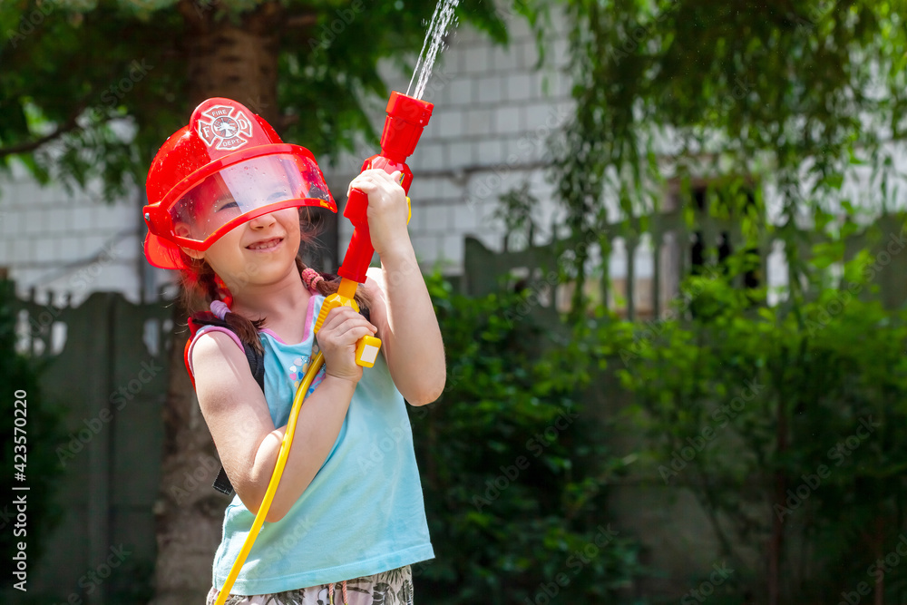 Little firefighter girl, young child in a red toy fireman helmet ...