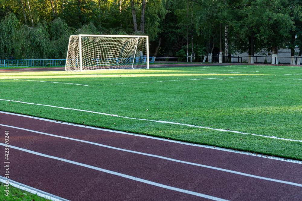 Small sports stadium with soccer field and running tracks. Summer, day ...