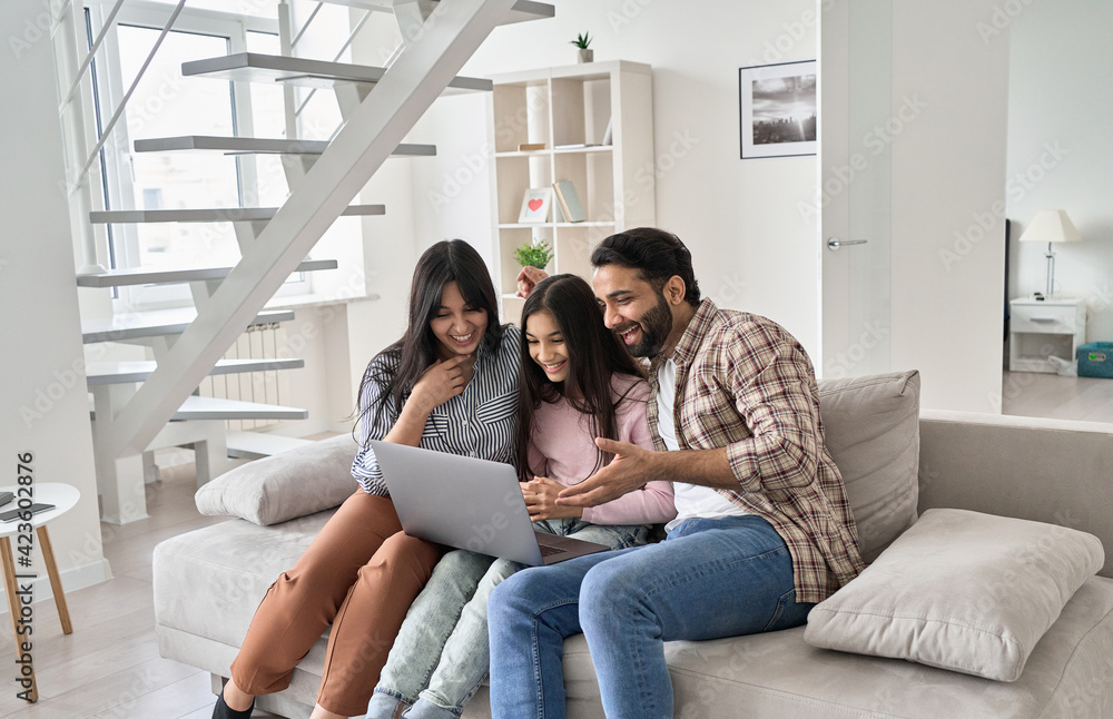 Happy indian family with child daughter having fun using laptop ...