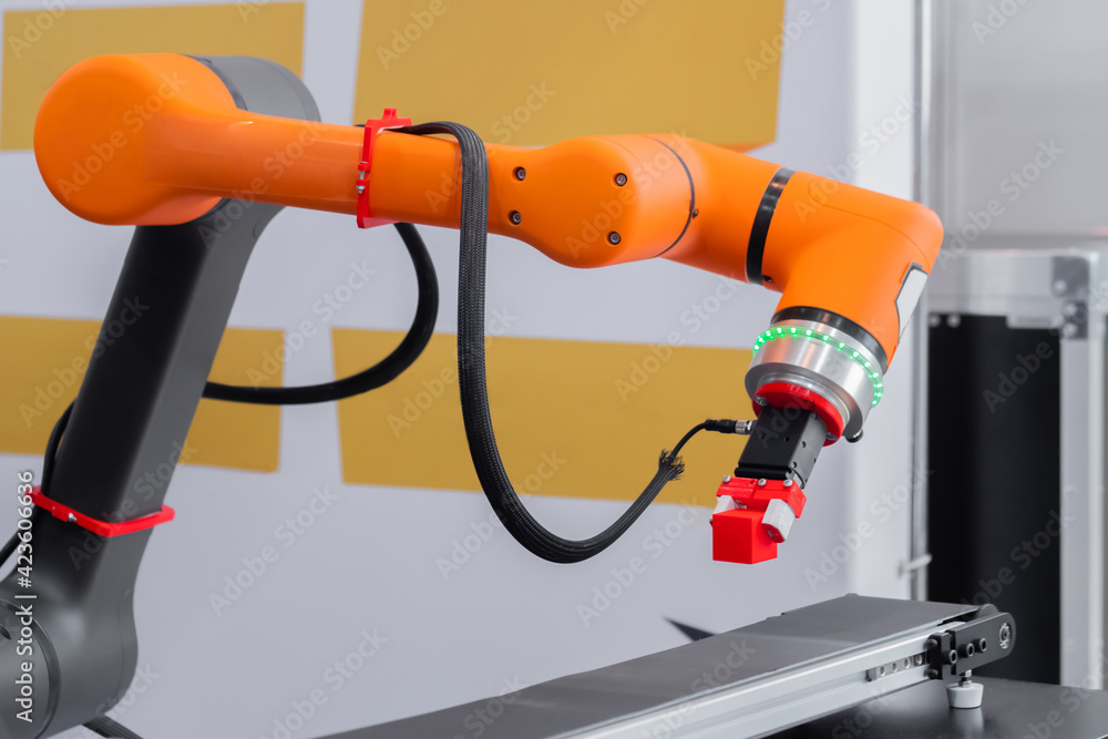 Orange pick and place robotic clamp arm manipulator moving red toy ...