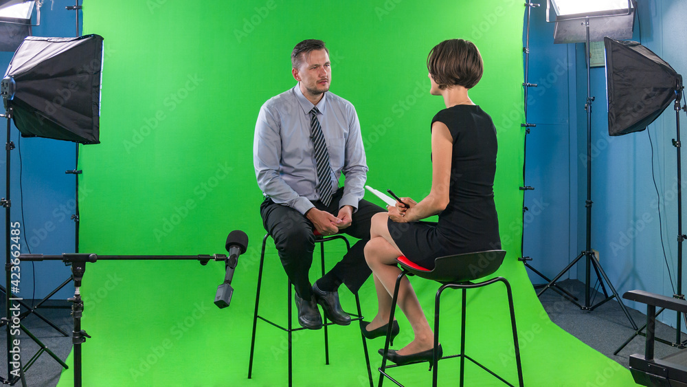 Female presenter interviewing man with pixelated and hidden face in tv ...
