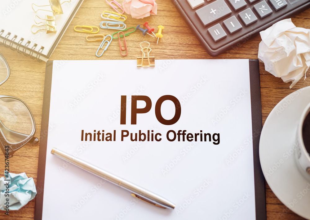 On a wooden table there is an office sheet of paper with the text IPO ...