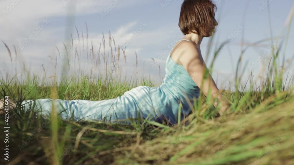 Ground level side view of flexible woman doing yoga in Cobra pose on ...